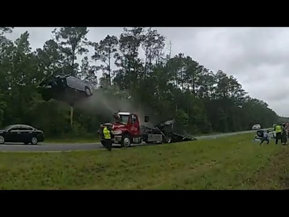 Driver sends car flying off parked tow truck ramp in front of police ...